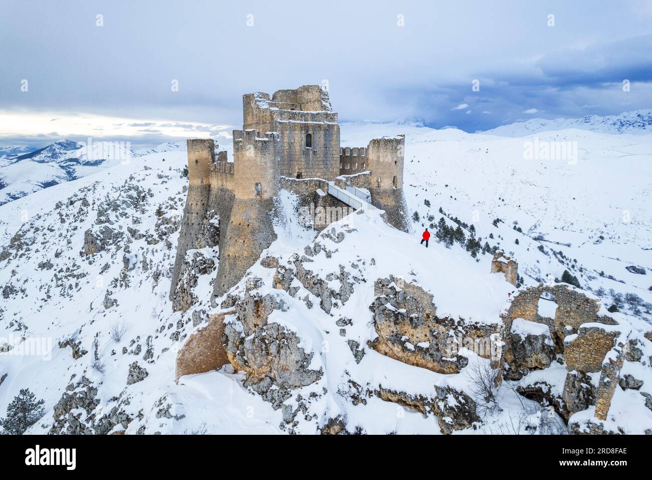 Man admiring the snowy medieval castle of Rocca Calascio after heavy ...