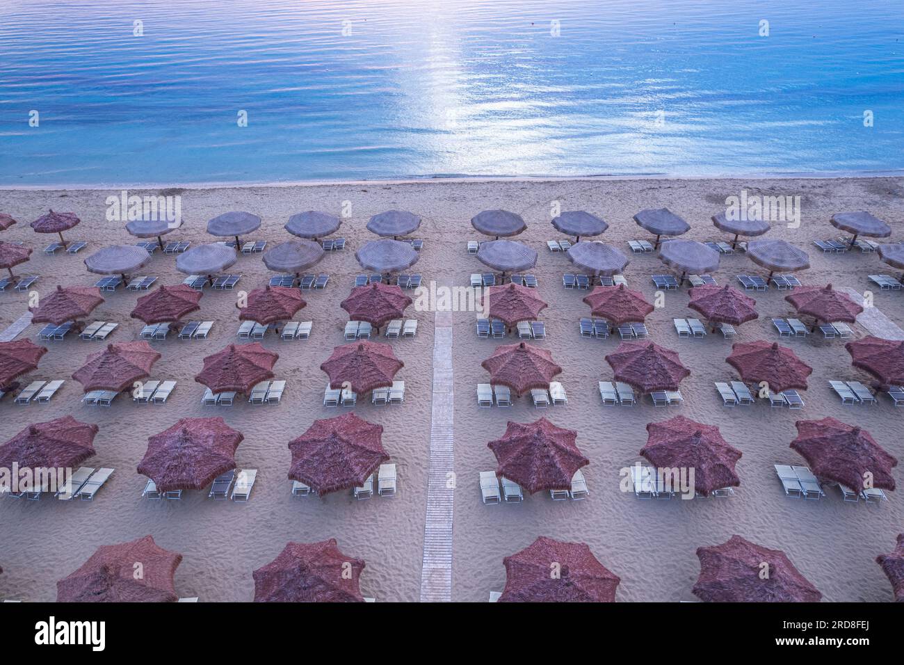 Aerial view of large group of tidy beach umbrellas facing the ...