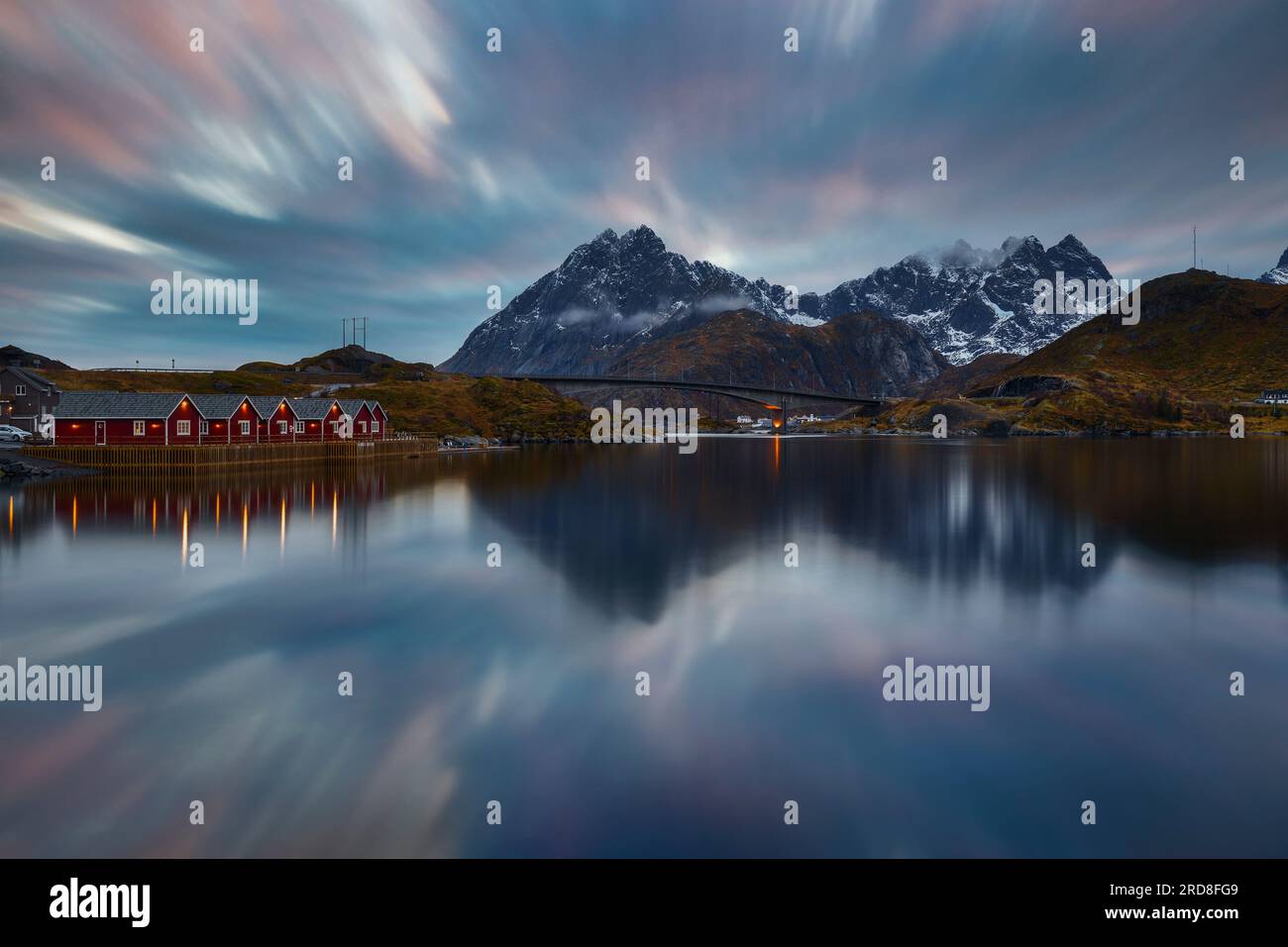 Norwegian fjord at blue hour with typical illuminated red cabins ...