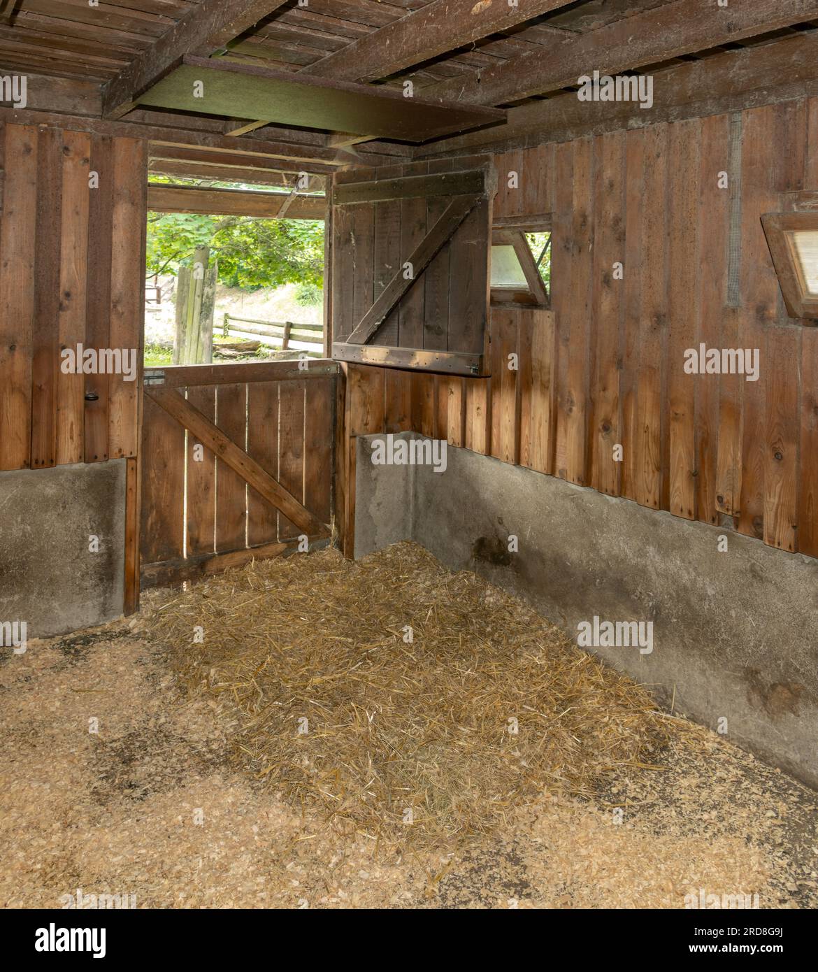 An empty barn with a door on a fenced meadow Stock Photo - Alamy