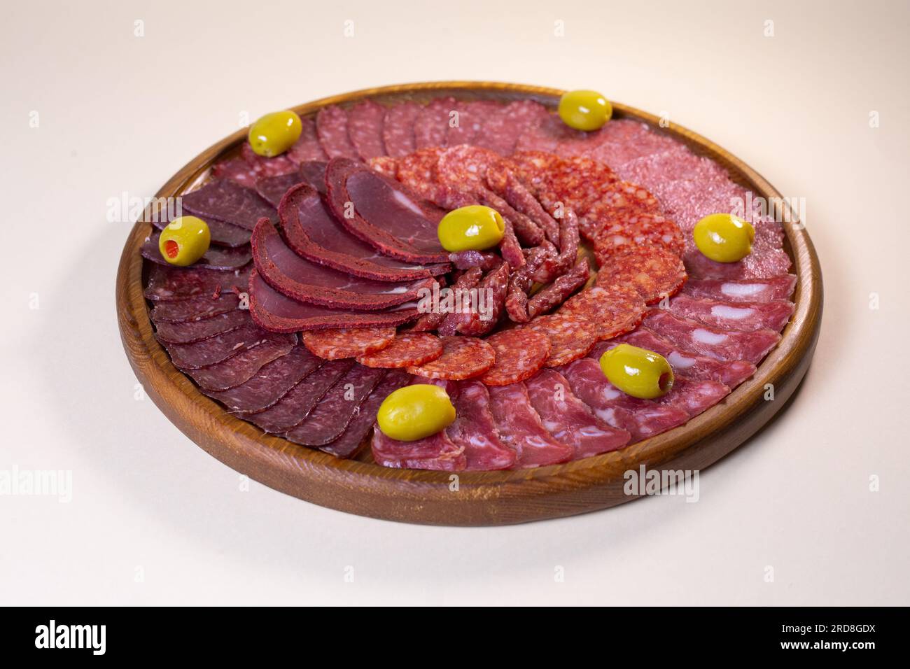 cold cuts of sausage delicacies on a wooden round stand Stock Photo - Alamy
