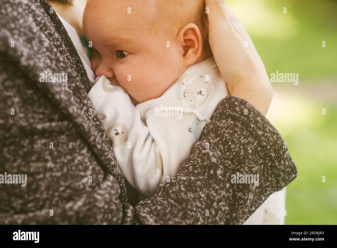 Mom cradles a newborn baby standing on the street Stock Photo - Alamy