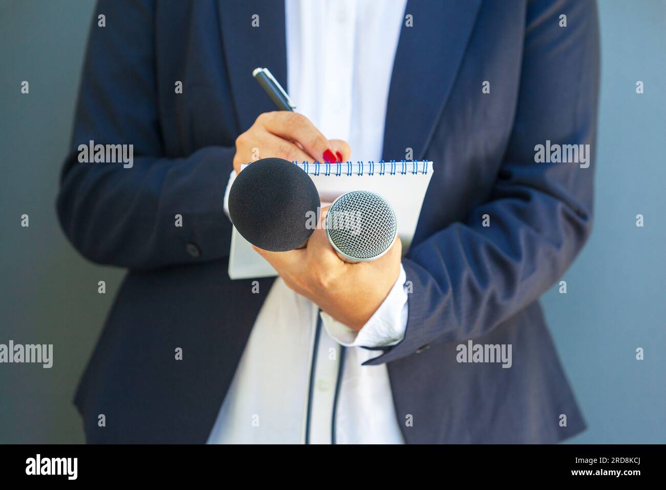 Female journalist at news conference or media event, writing notes ...