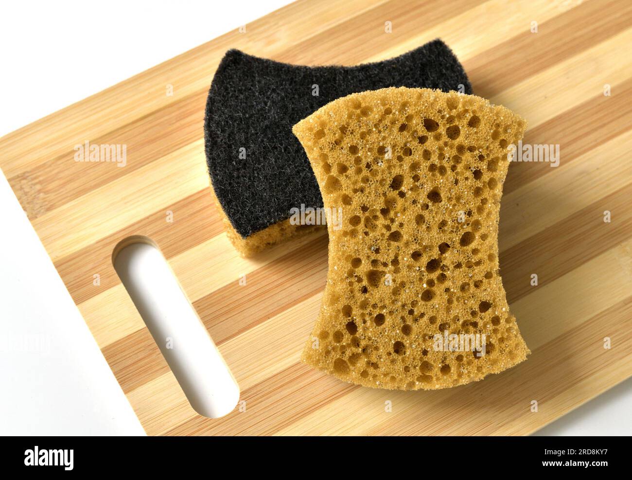 Sponge for washing dishes lies on astriped wooden cutting board Stock ...