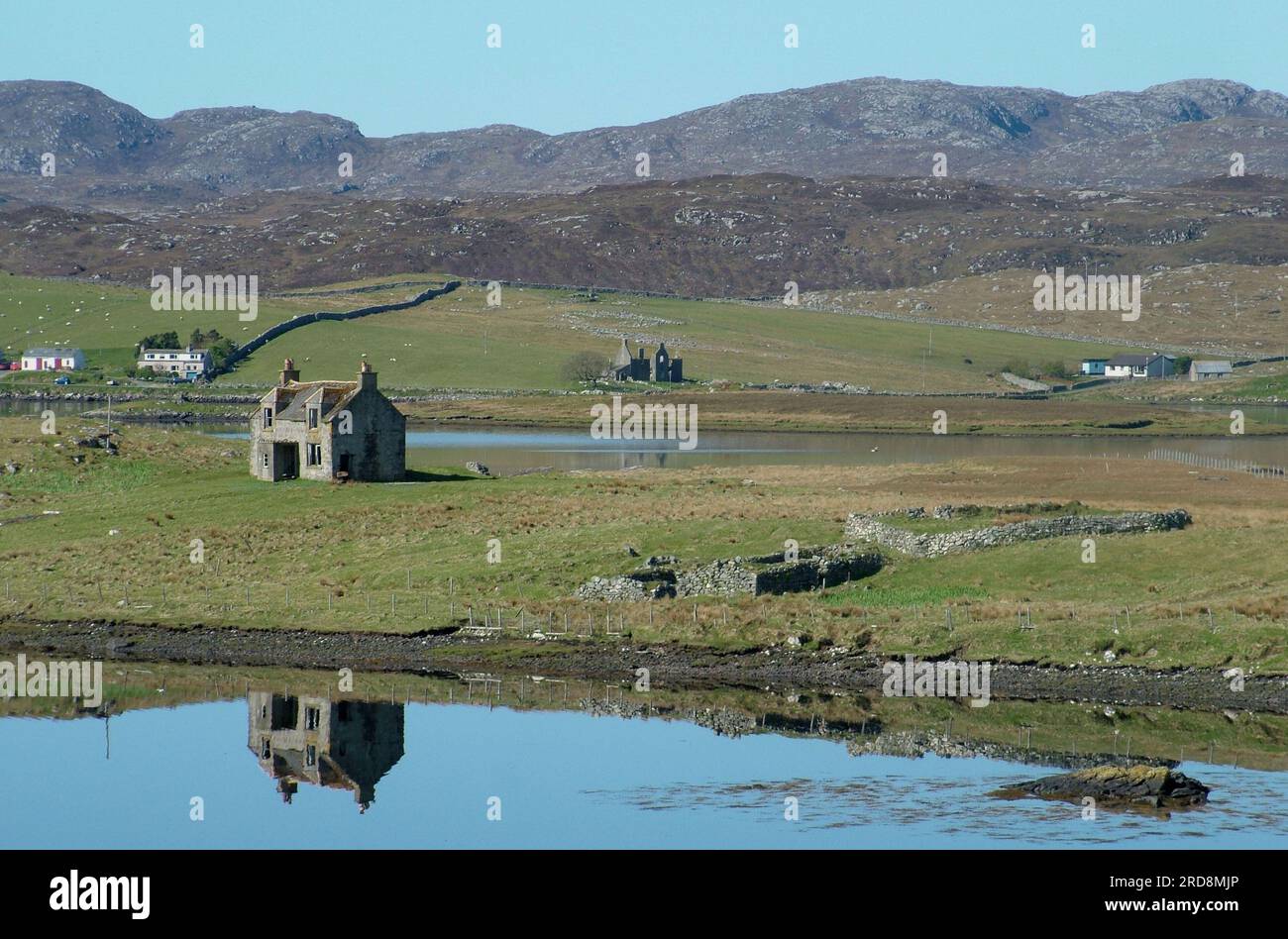 Reflection of an abandoned ruined cottage in the tranquil waters of ...