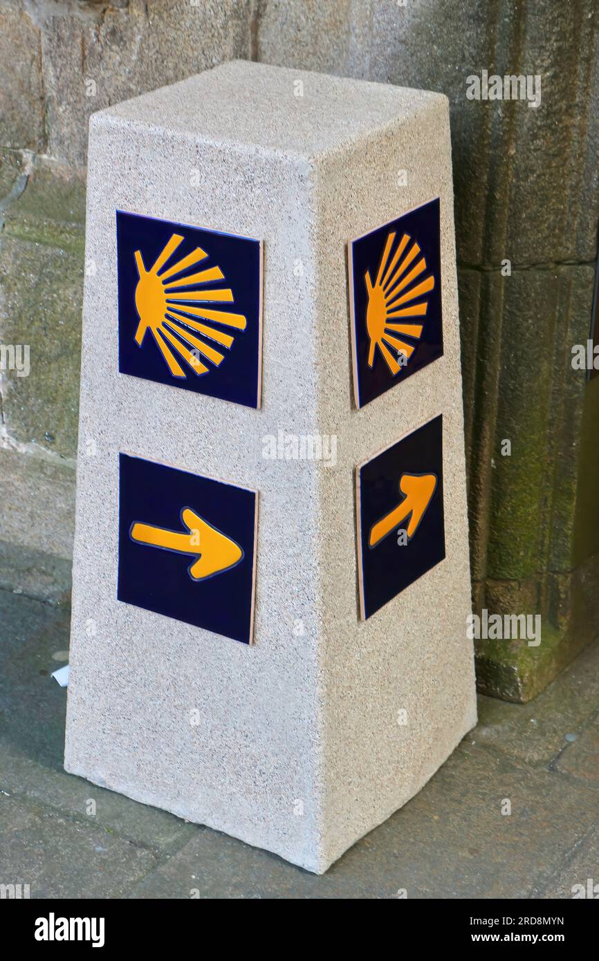 The Way of Saint James scallop shells and arrow signs on a stone post ...