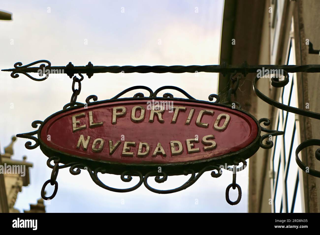 Old hanging painted metal sign outside El Portico Novedades gift shop ...