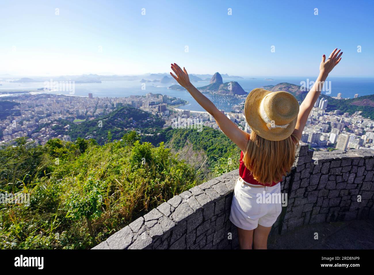 Aerial view of happy young tourist woman with raising arms on belvedere ...