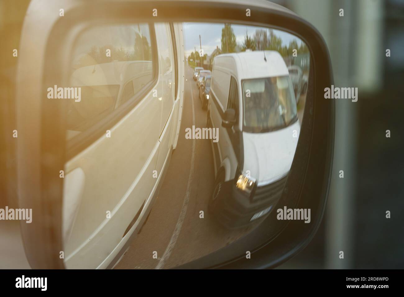 Reflection in the right mirror of a truck in the sun. A cargo bus, cars ...