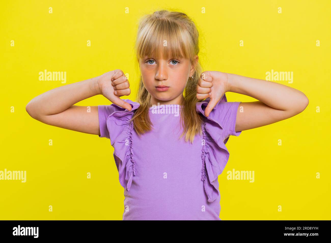 Dislike. Upset young preteen child girl kid showing thumbs down sign ...