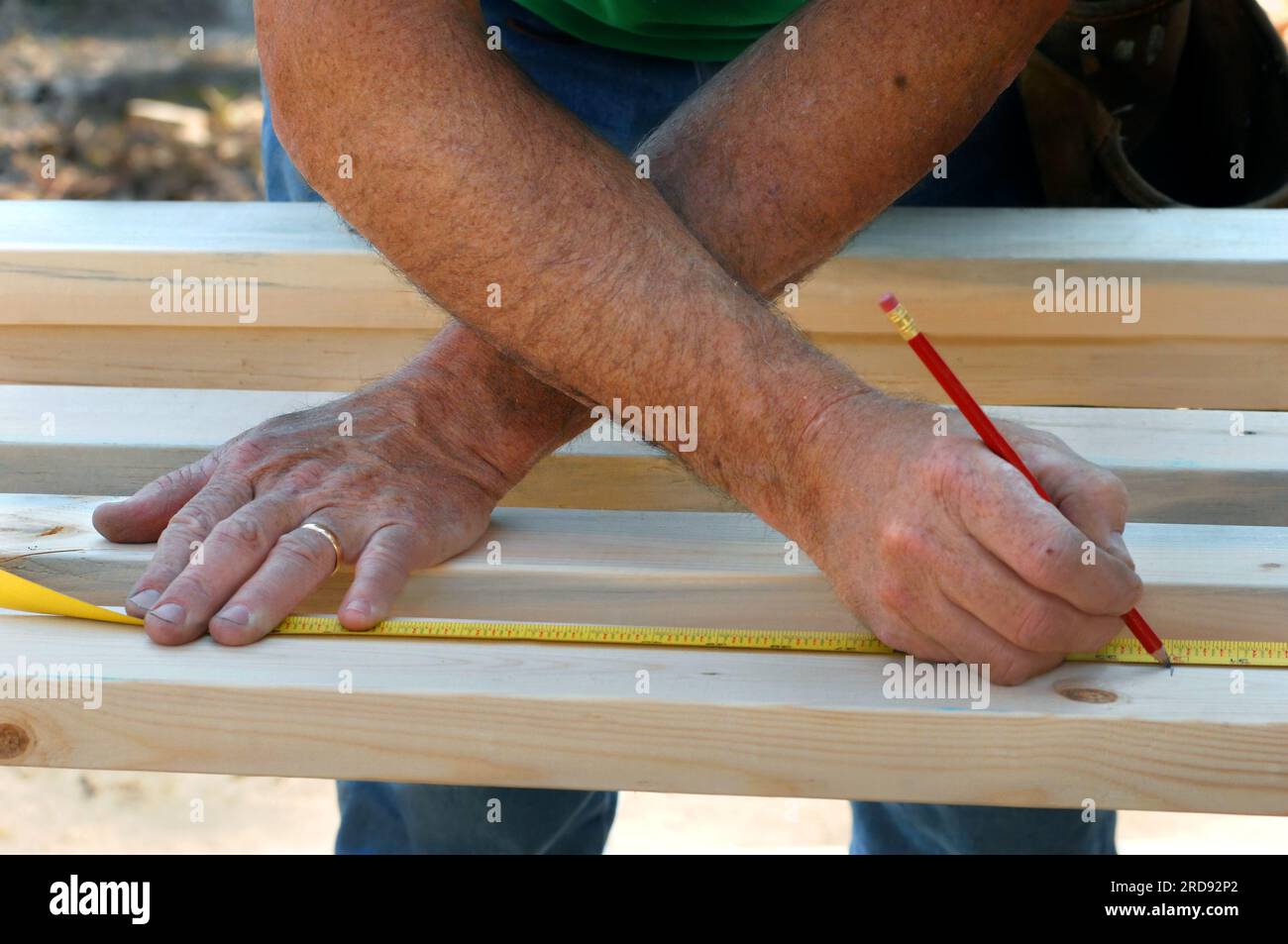 Carpenter makes marks using his tape measure to know the exact place to ...
