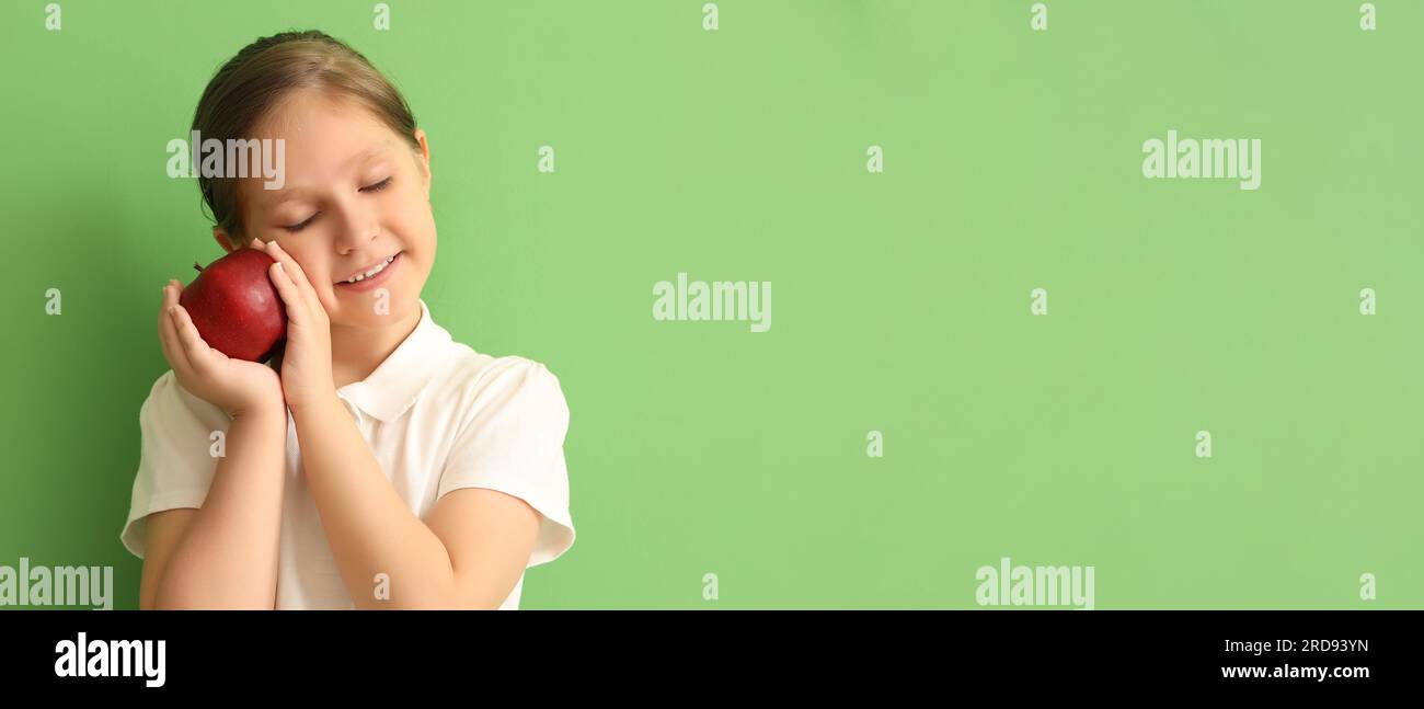 Little girl holding apple on green background with space for text Stock ...