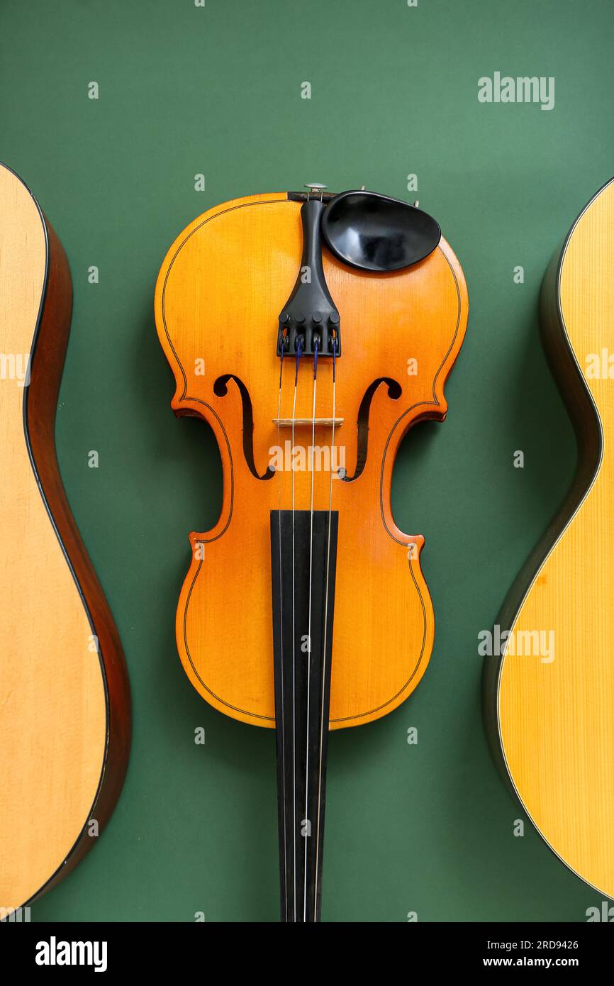 Acoustic guitars and violin on color background Stock Photo - Alamy