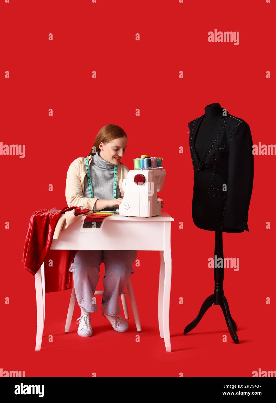 Female dressmaker sewing at table on red background Stock Photo - Alamy