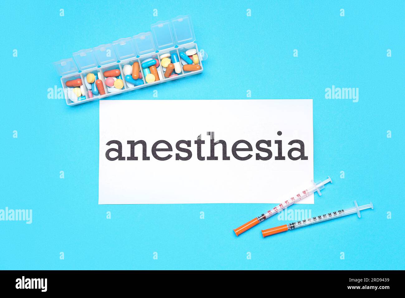 Paper with word ANESTHESIA, pills and syringes on blue background Stock ...