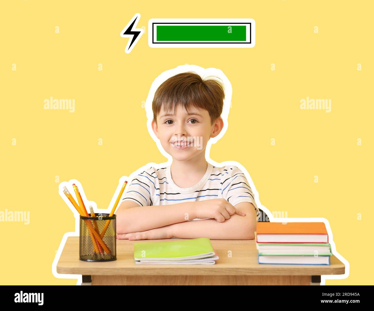 Smart little boy sitting at desk against yellow background Stock Photo ...