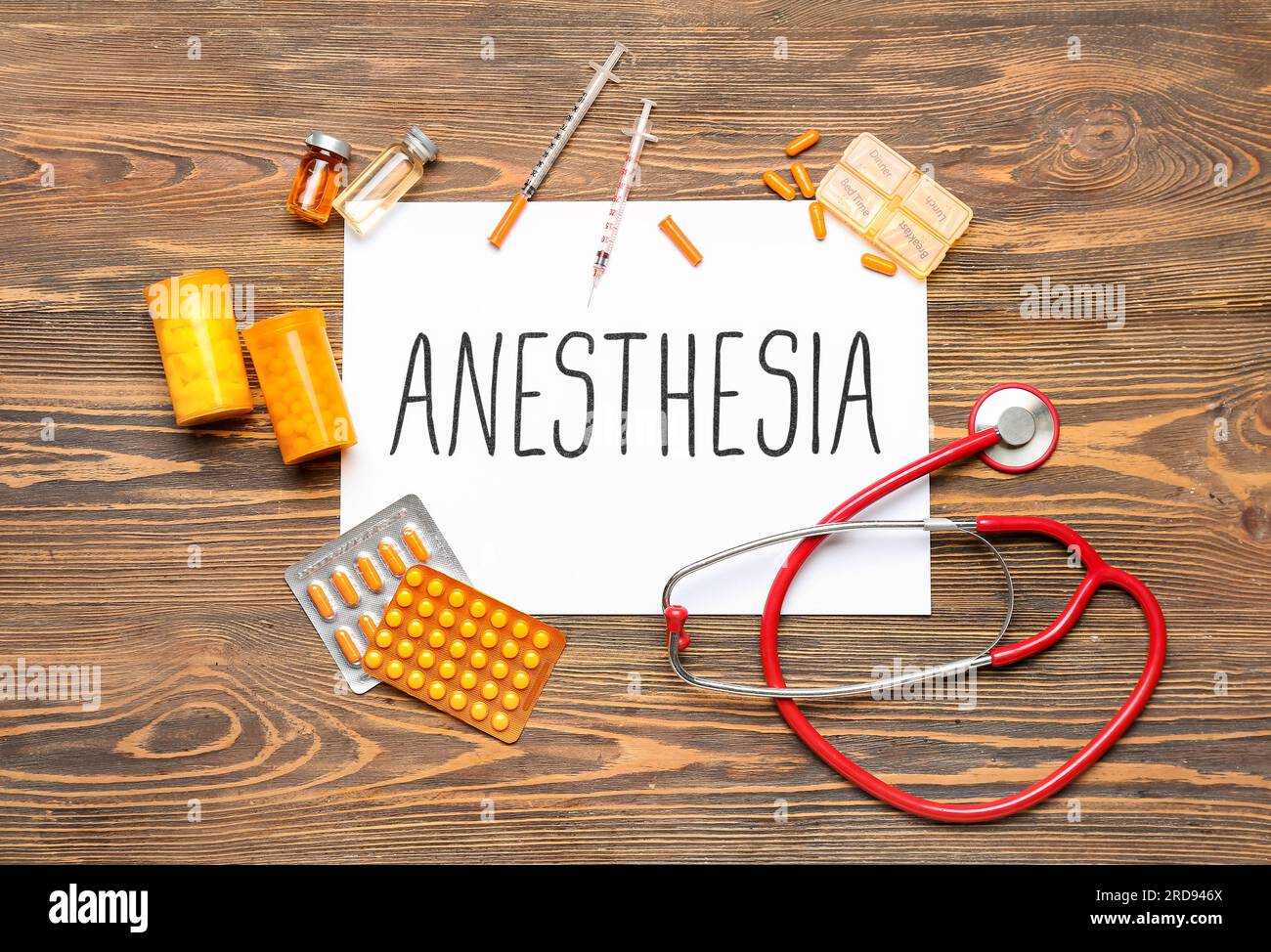 Paper with word ANESTHESIA and medical supplies on wooden background ...