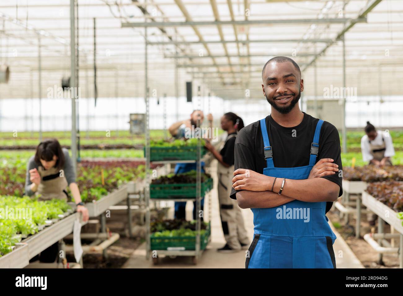 Cheerful farm worker in eco friendly agriculture certified organic ...