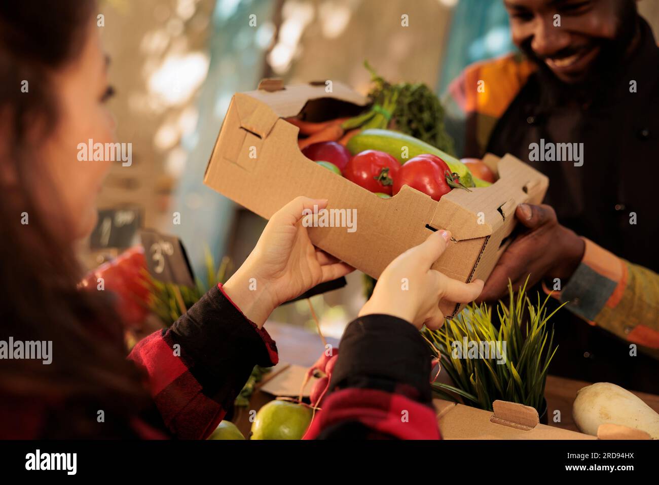 Young happy African guy farmers market vendor giving fresh organic ...