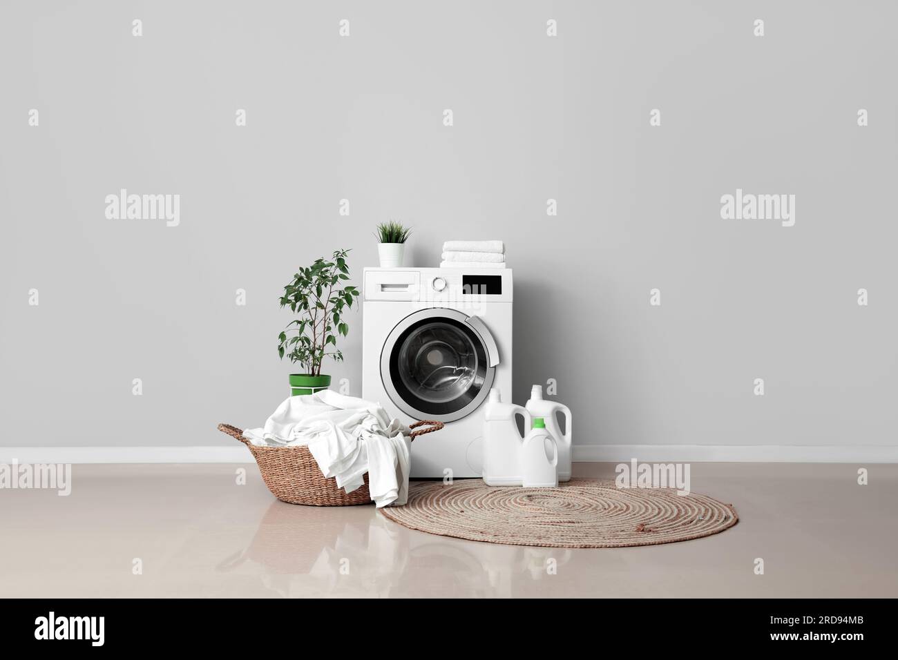 Washing machine, bottles of detergent and basket with dirty laundry ...