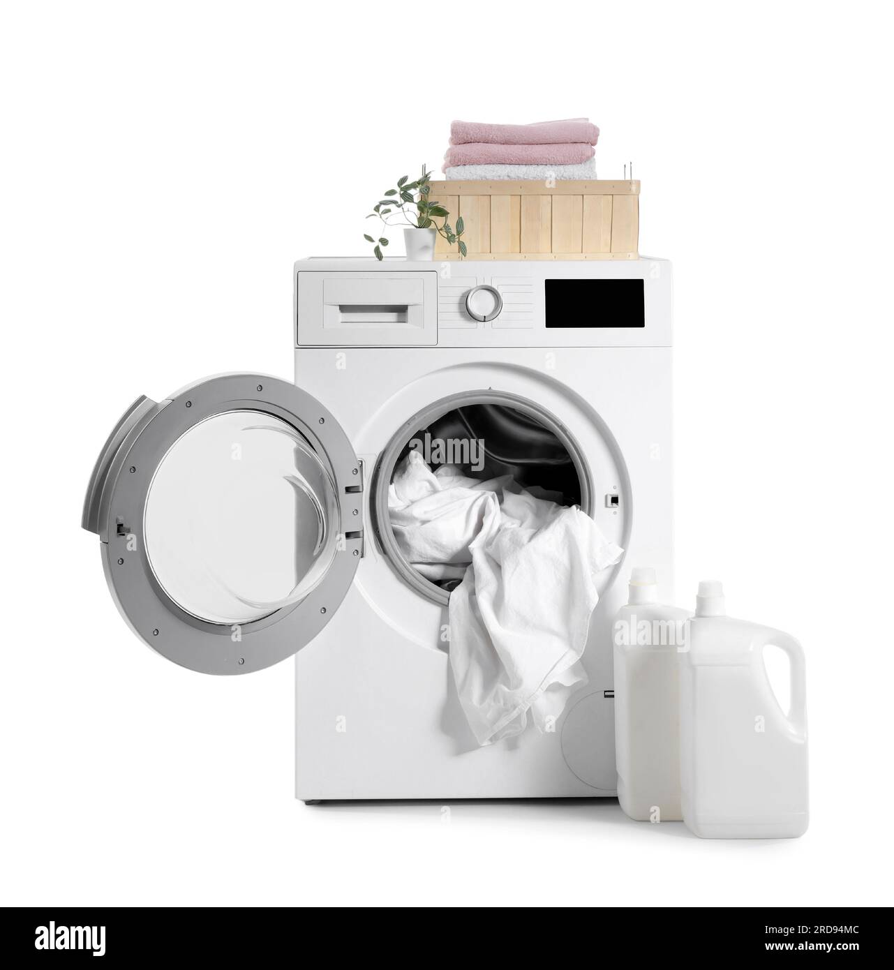 Opened washing machine with laundry, bottles of detergent and towels ...
