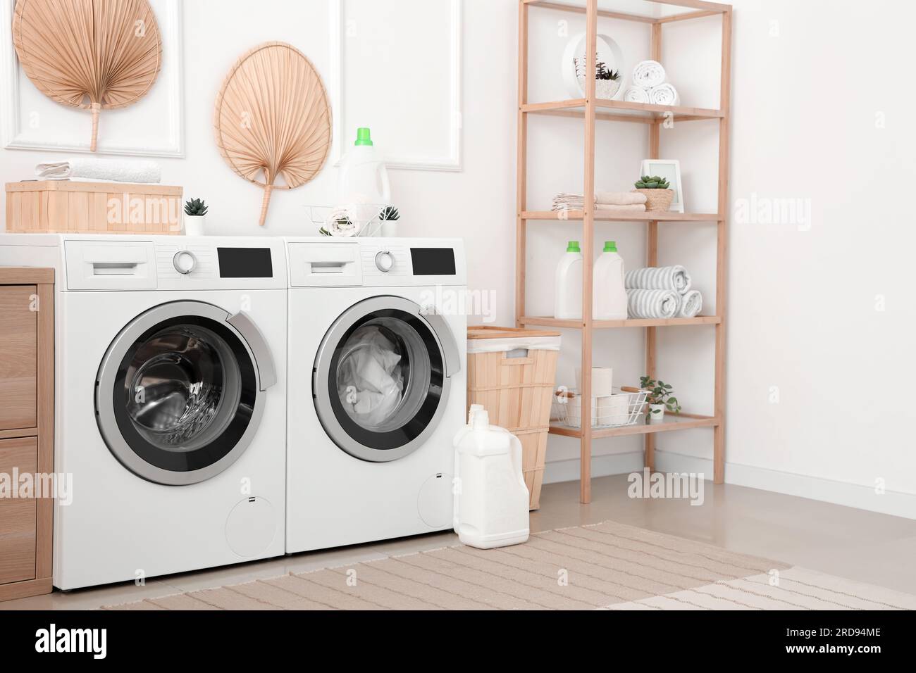 Interior of laundry room with washing machines, wooden cabinet and ...
