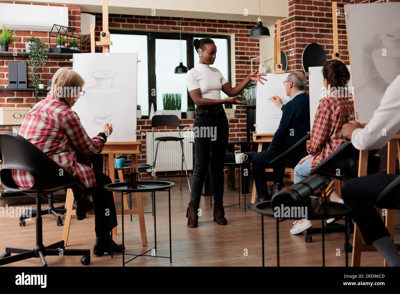 Young friendly African American woman art instructor standing in ...