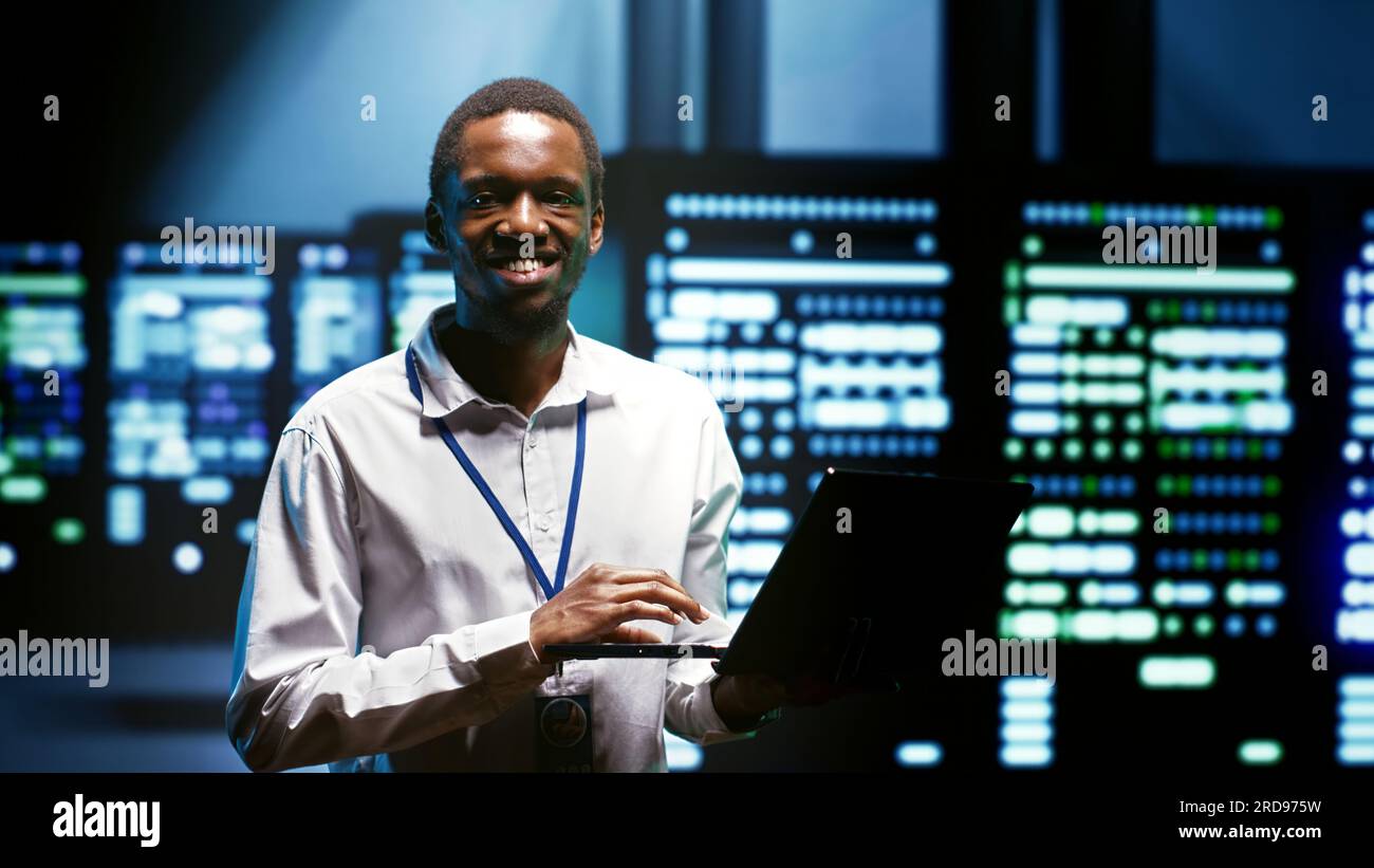 Computer scientist using tablet to analyze server cabinets providing computing resources and ...