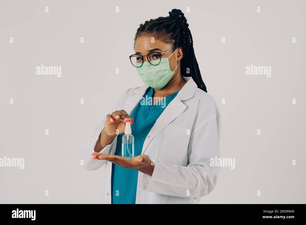 Doctor sanitizing hands wears mask, hygiene practice Stock Photo - Alamy