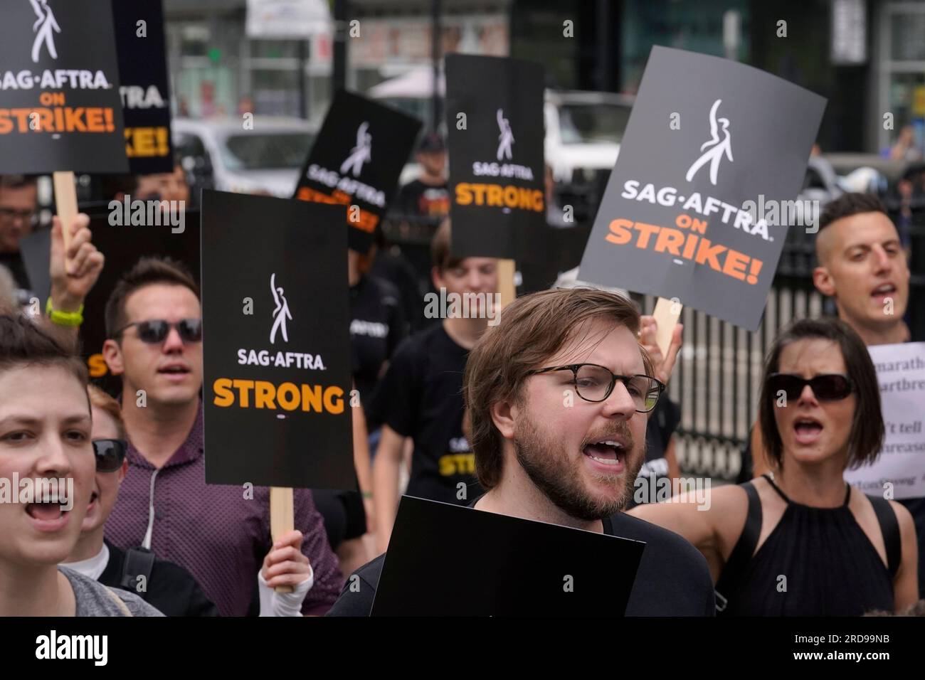 Striking film and television actors and supporters display signs and ...