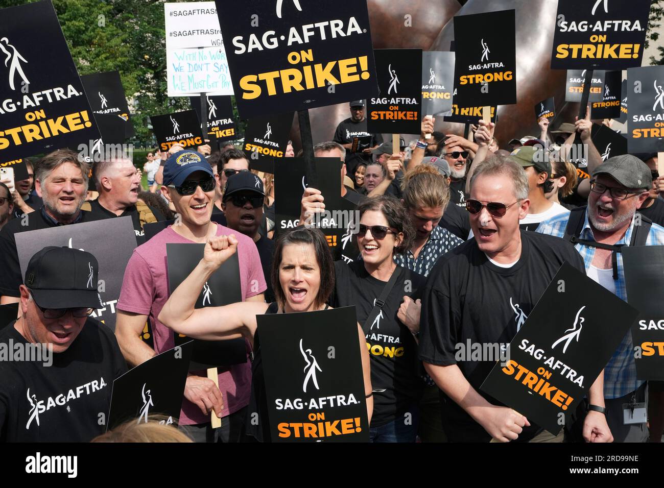 Striking film and television actors and supporters display signs and ...