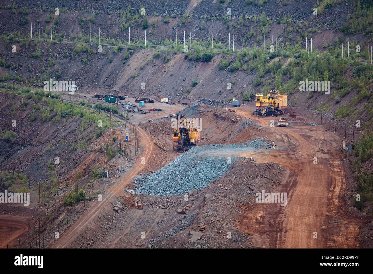 Excavators and dump trucks working on earthmoving at open pit mine in ...