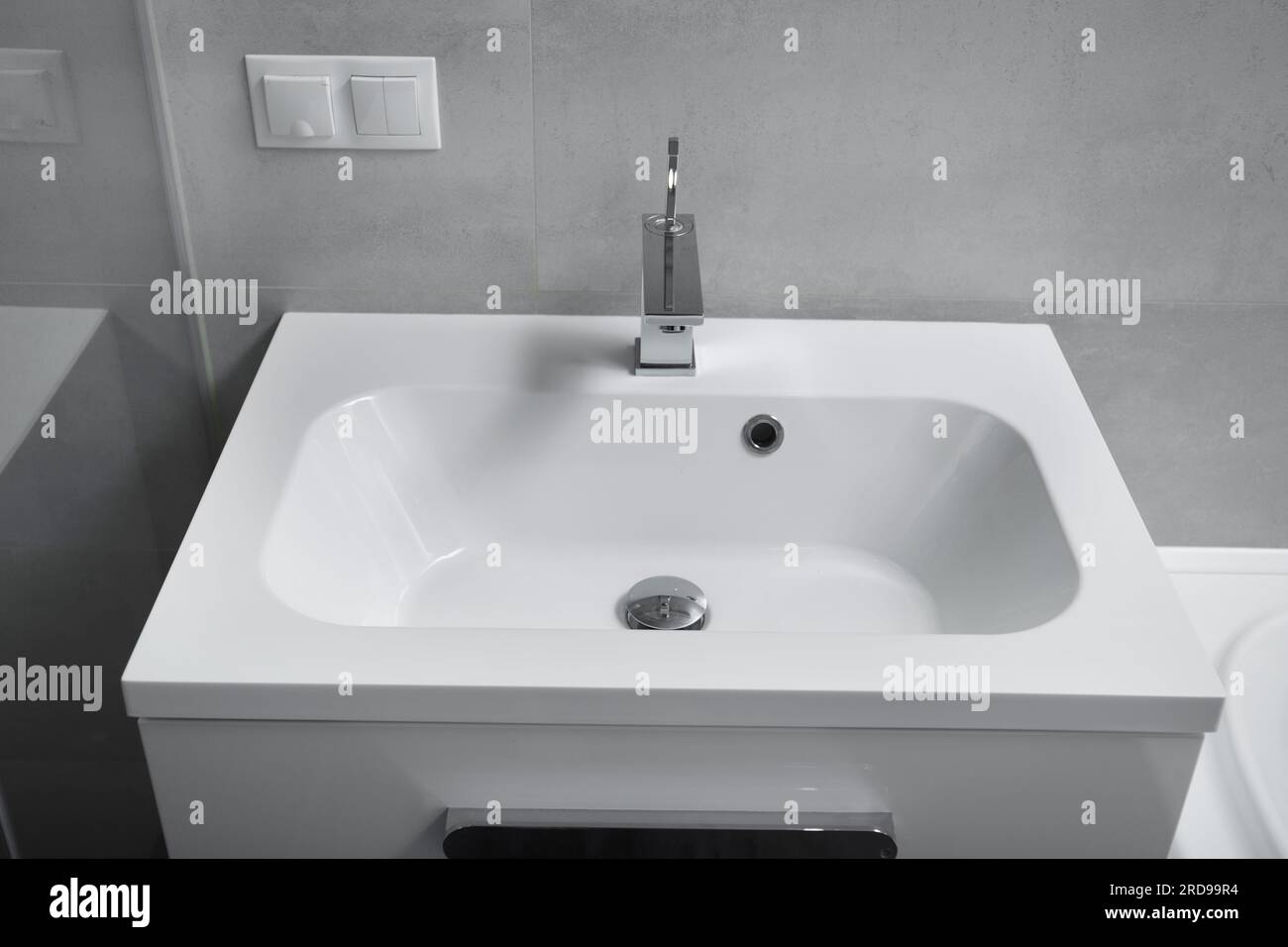 Modern bathroom interior, white washbasin with drawers, chrome faucet ...