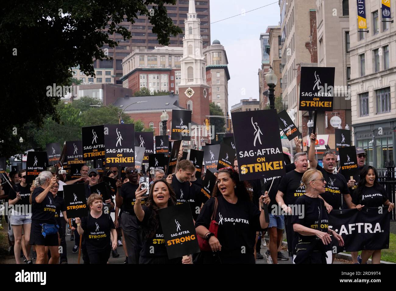 Striking film and television actors and supporters display signs and ...