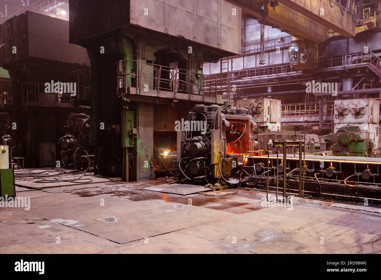 Rolled metal factory hot steel bar on conveyor moving through rollers ...