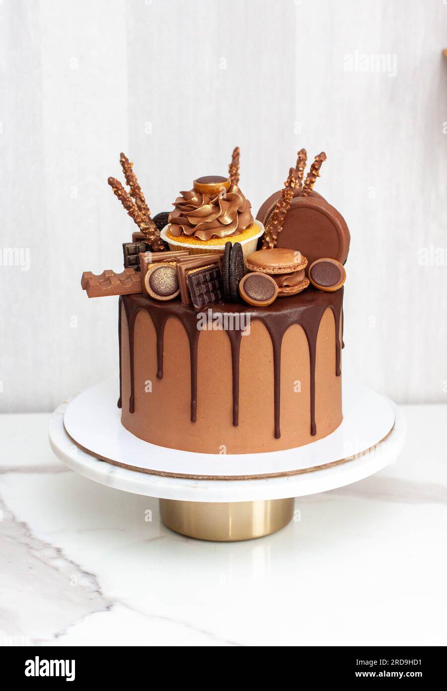 Chocolate cake richly decorated with assorted sweets, cupcake, cookies ...