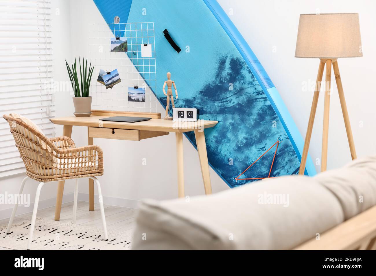 SUP board, workplace and sofa in room. Interior design Stock Photo - Alamy