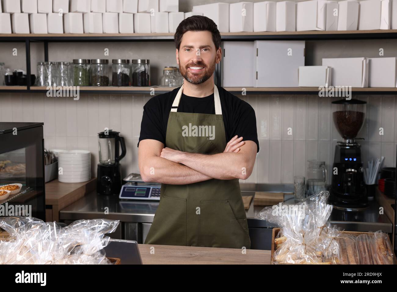 Happy seller at cashier desk in bakery shop Stock Photo - Alamy