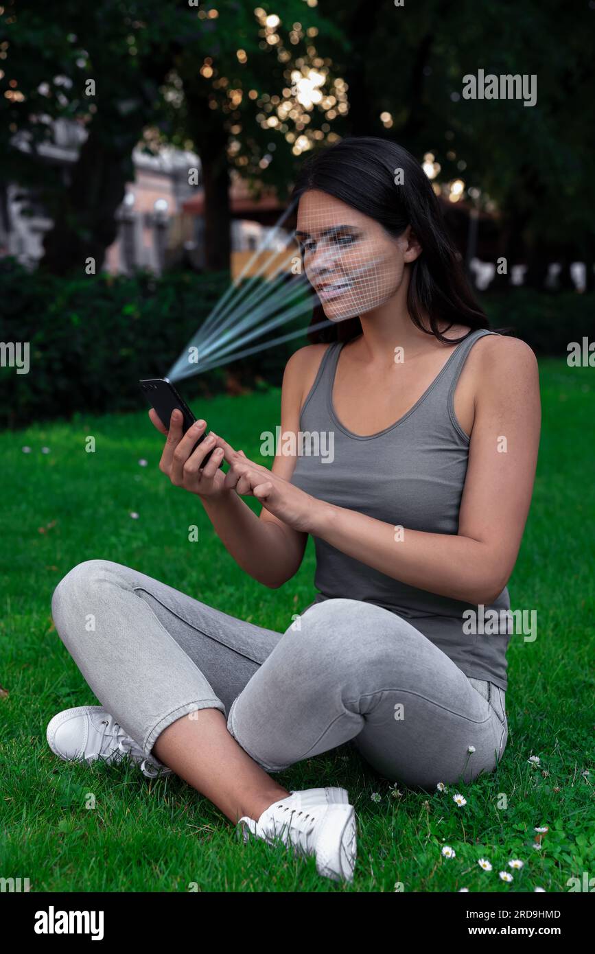 Woman Using Smartphone With Facial Recognition System Outdoors