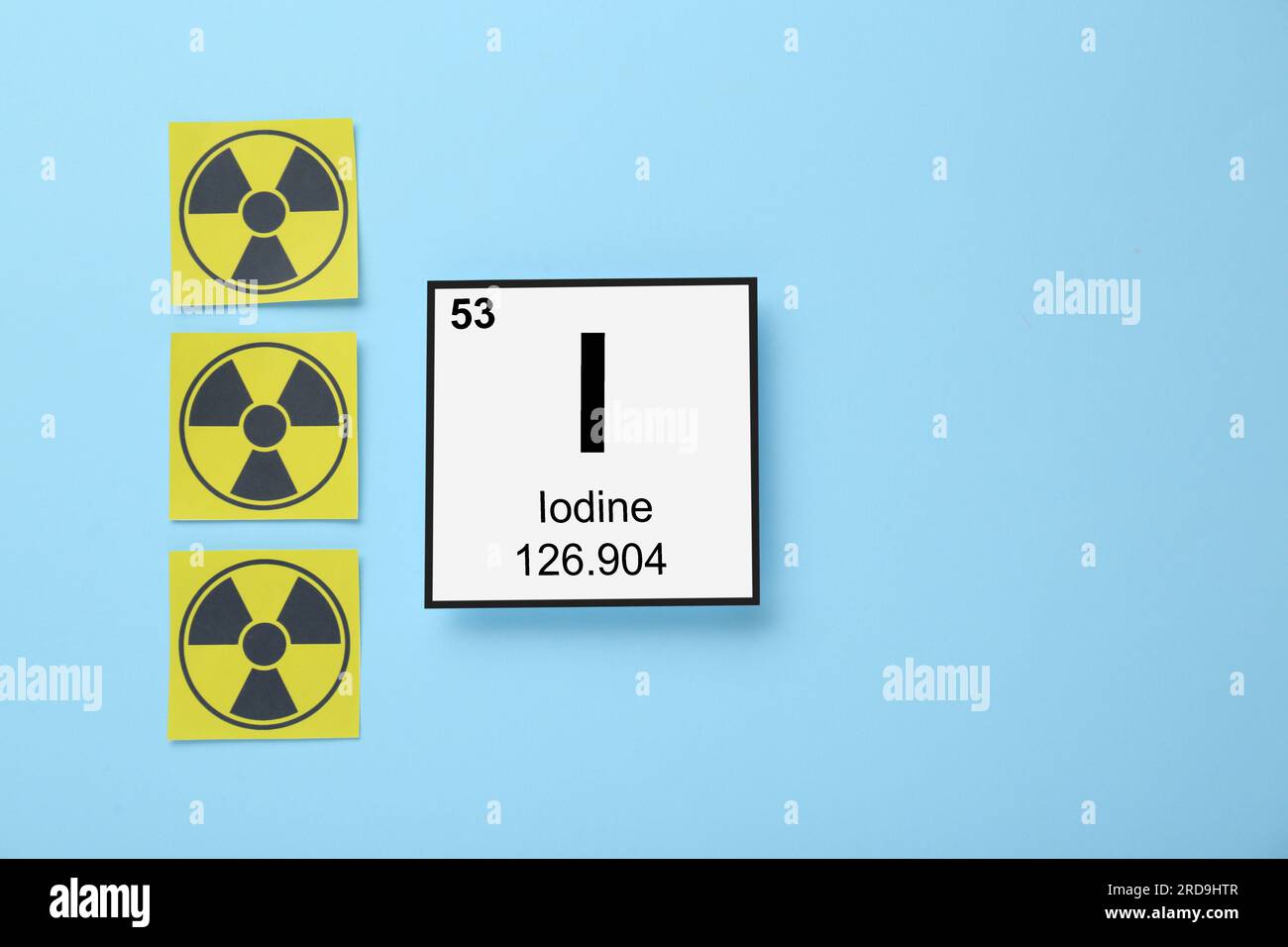 Card with chemical element Iodine and radiation signs on light blue ...