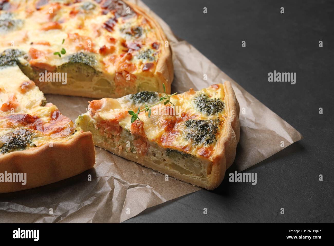 Delicious homemade quiche with salmon and broccoli on parchment paper ...