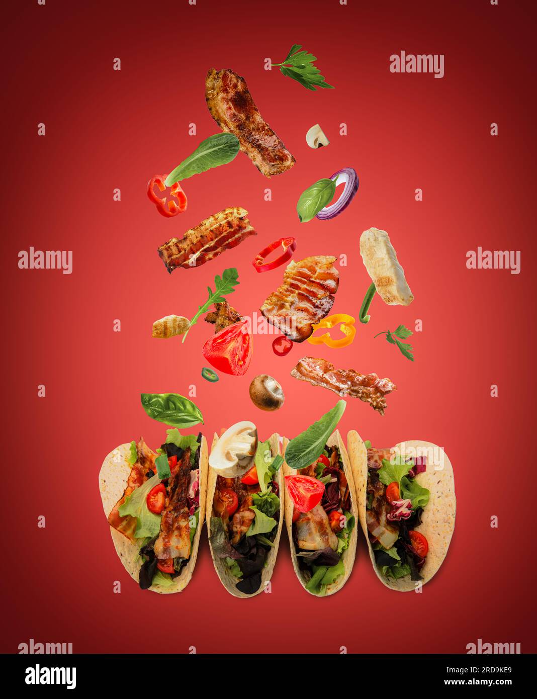 Delicious tacos. Ingredients falling into tortillas on red background ...