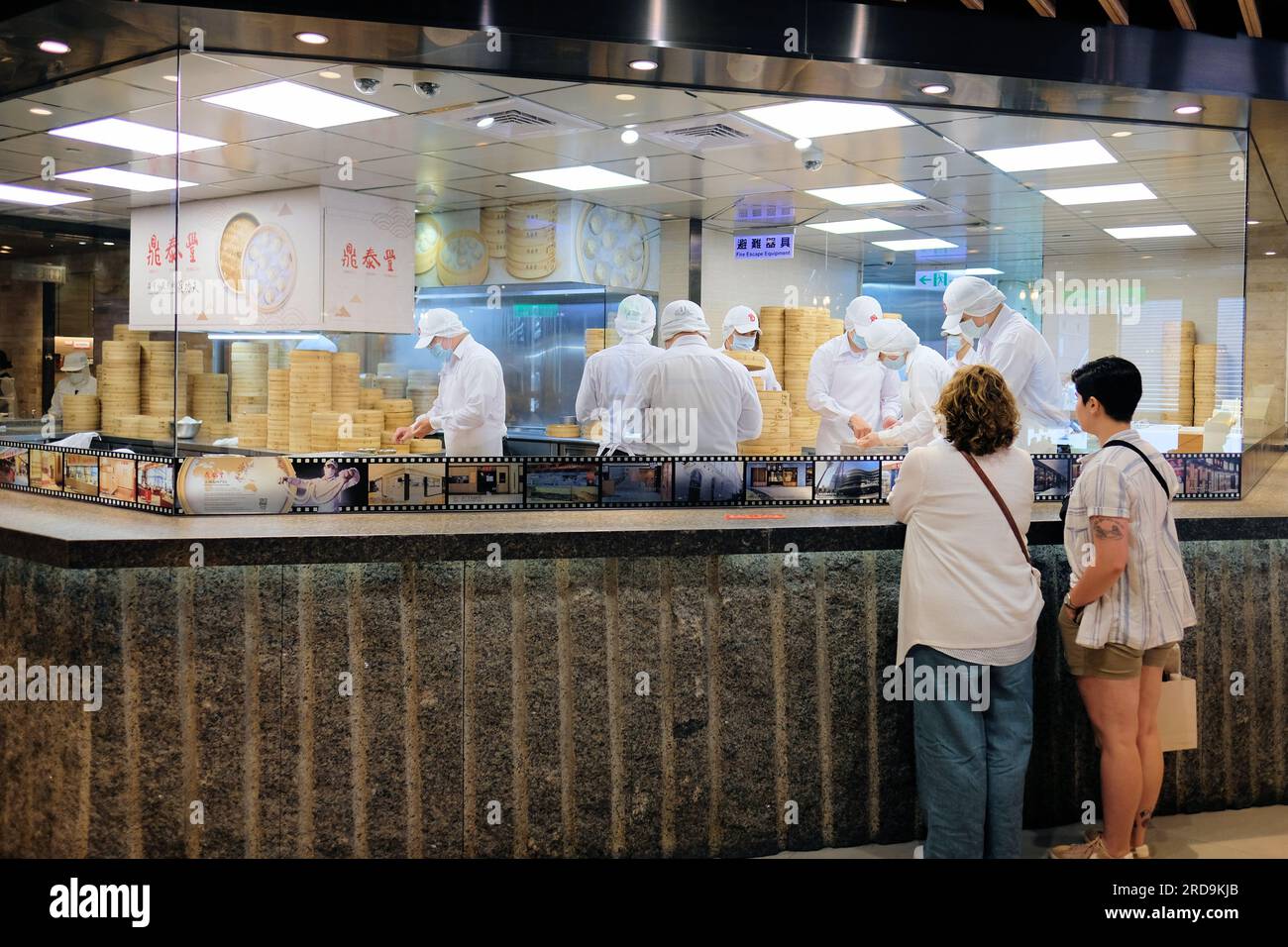 Guests watching kitchen staff making dumplings, bao, and other Chinese ...