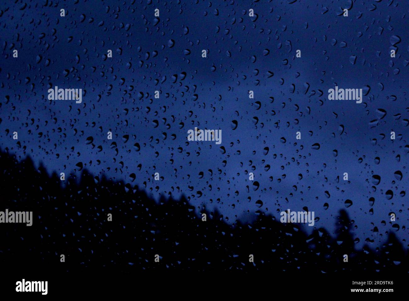 Raindrops are on a window the looks to the dark night outside Stock ...