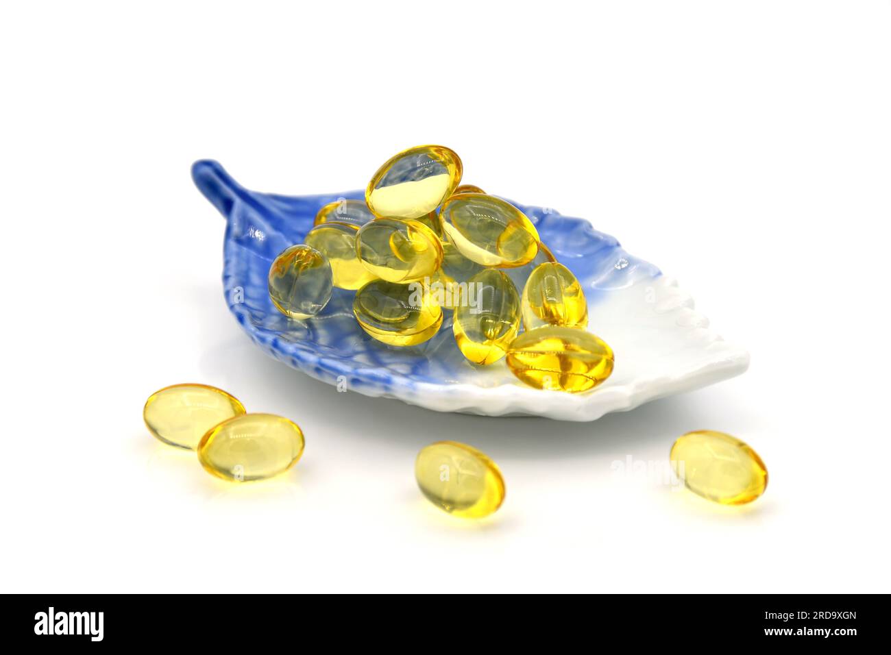 Dietary supplement oil soft gelatin capsules on small ceramic dish ...