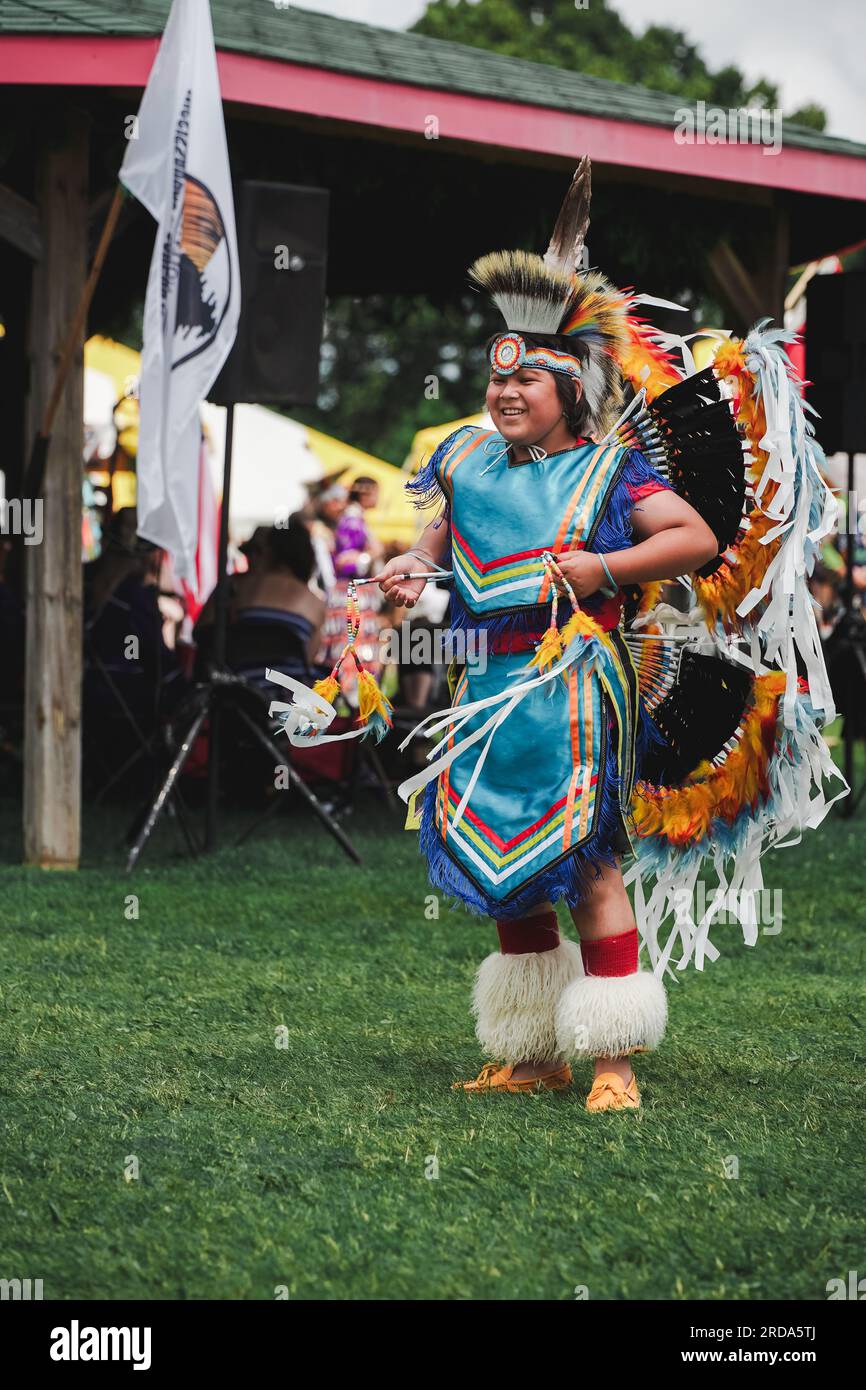 Native American teenager dressed in traditional Indian dancing outfit at pow wow event to ...