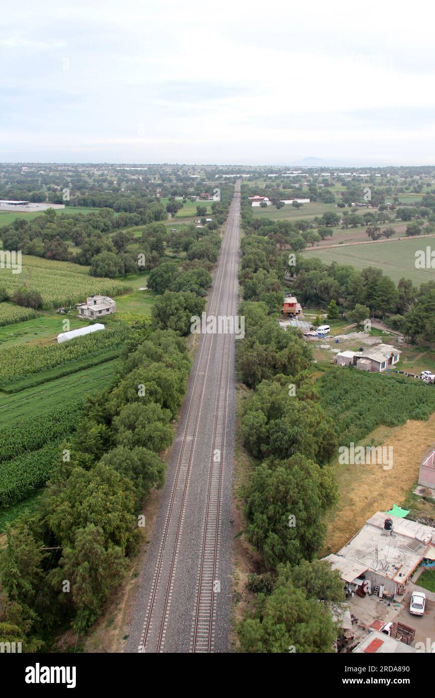 View of long train tracks, greenery and planting fields to the sides ...