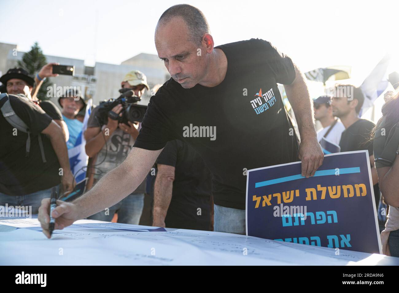 Tel Aviv, Israel. 19th July, 2023. An Israeli reservist signs a ...