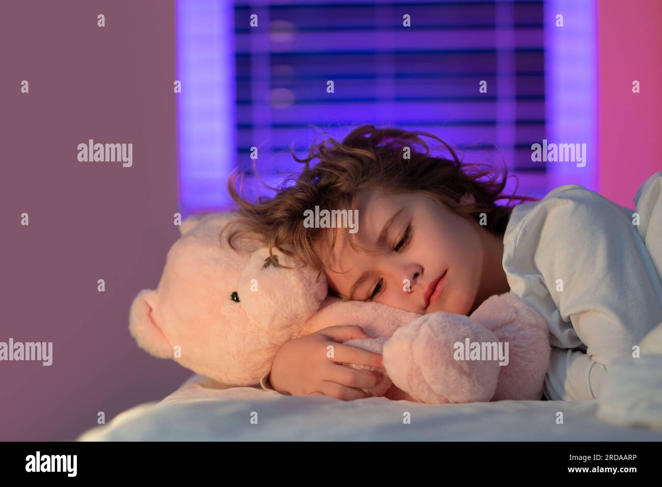 Night sleep. Cute child sleeping with a toy teddy bear on bed at home ...