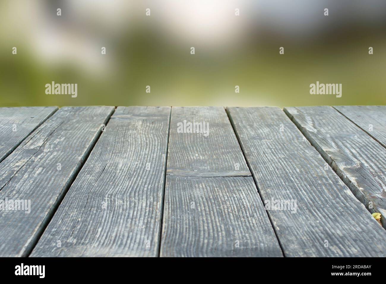 old wood boards table with defocused green grass background, soft focus ...